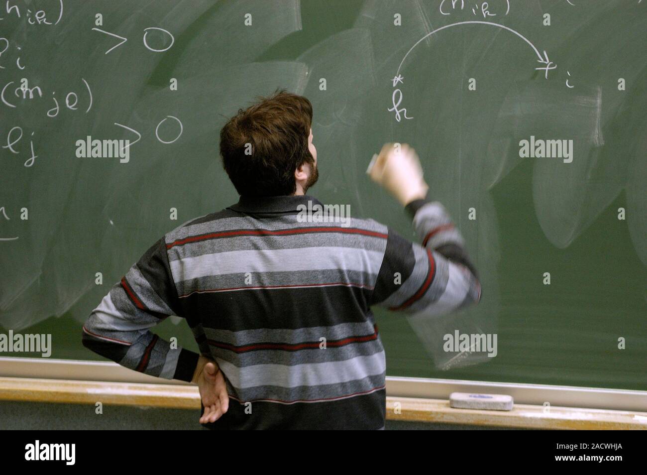Mathematical research. Mathematician at a blackboard studying ...