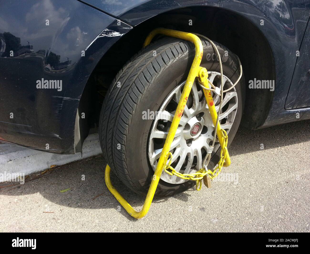 Car wheel clamped for illegal parking Stock Photo - Alamy