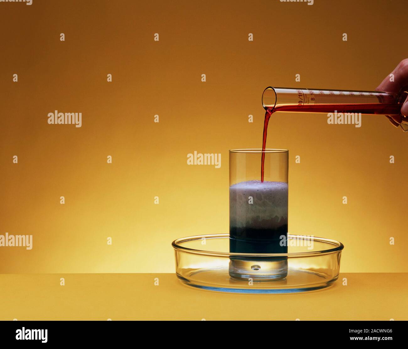 Causing chemical reaction by pouring red liquid from test tube into ...