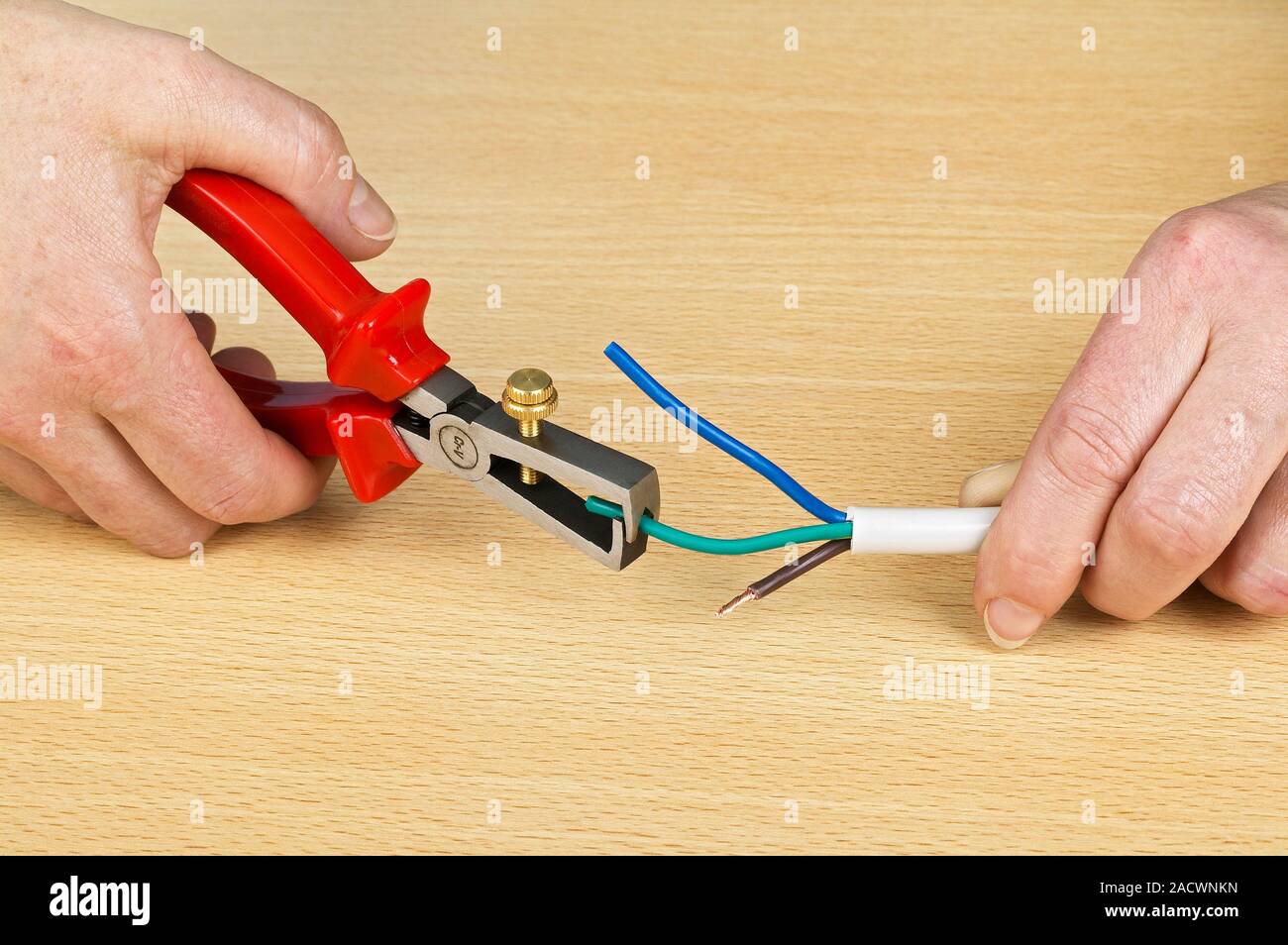Using wire strippers to clip electric cables Stock Photo - Alamy