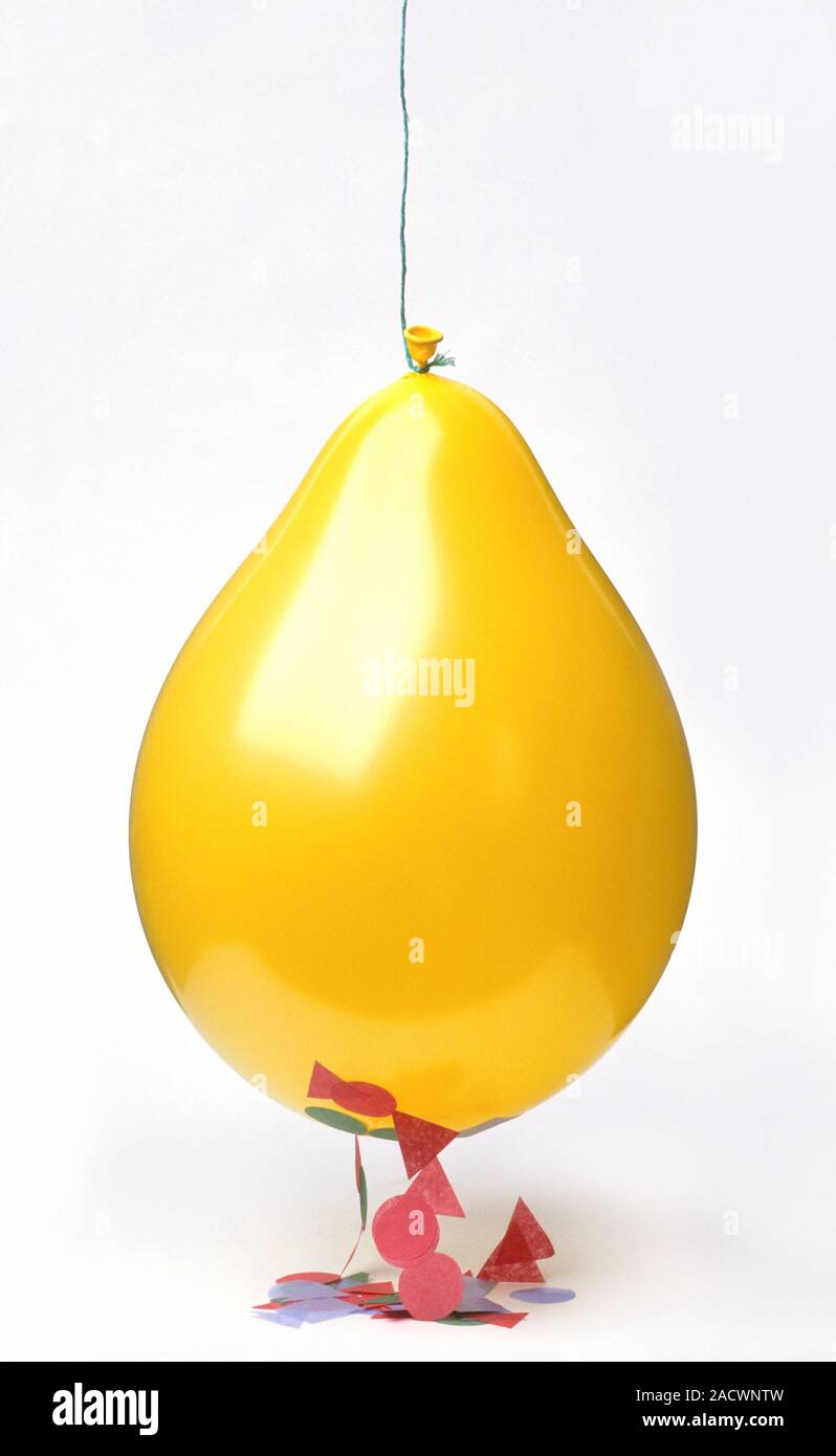 Electrically charged balloon attracting pieces of coloured paper Stock ...