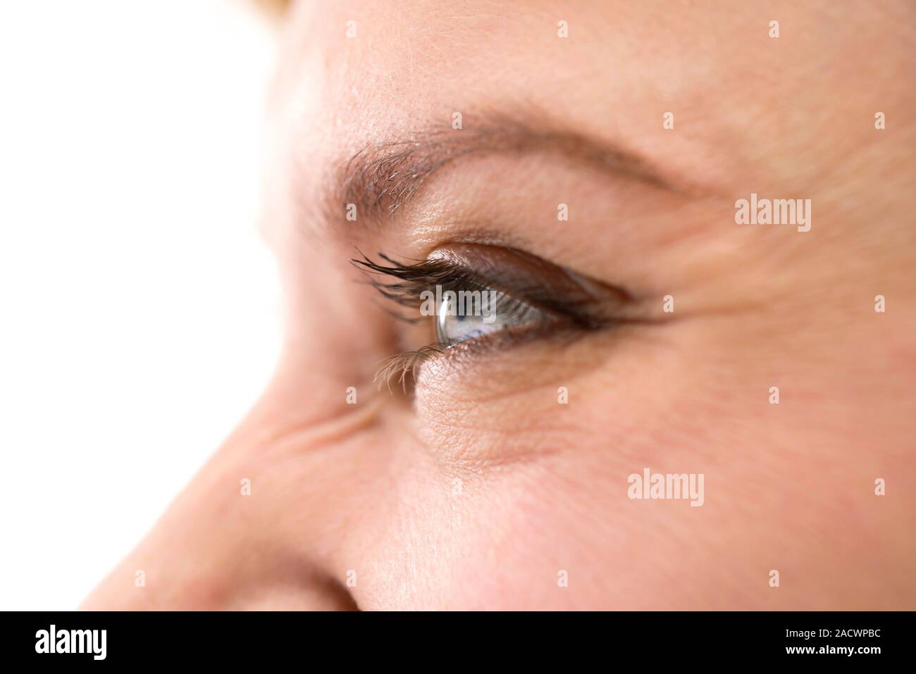 Smiling woman's eye. Close-up side view of the creased skin around the ...