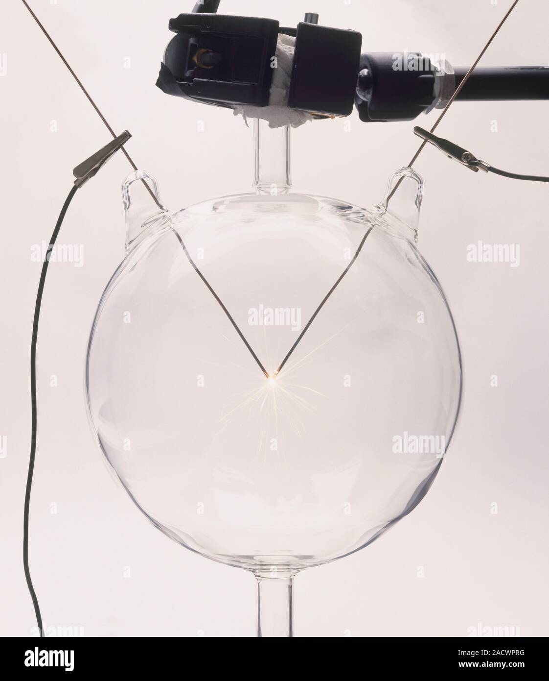 Electrodes igniting light inside glass vacuum sphere of natural gas ...