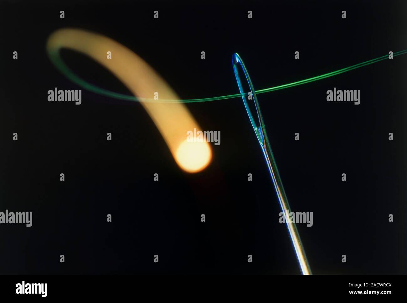 Fibre optic cable being passed through eye of needle Stock Photo - Alamy