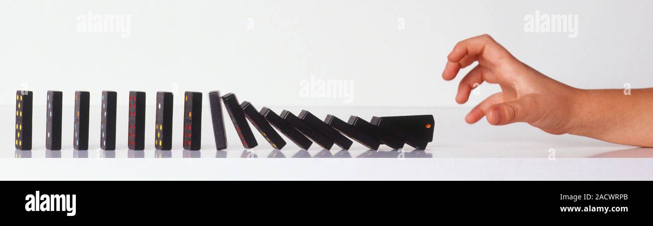 Child's hand pushing over a row of dominoes Stock Photo - Alamy