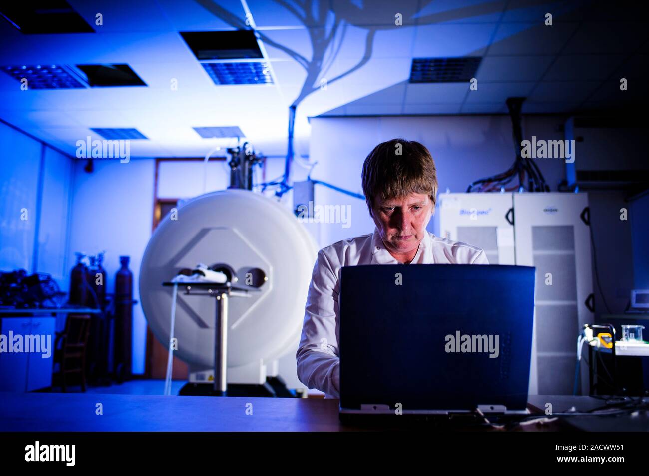 MRI scanning research. Researcher using a laptop computer in a ...