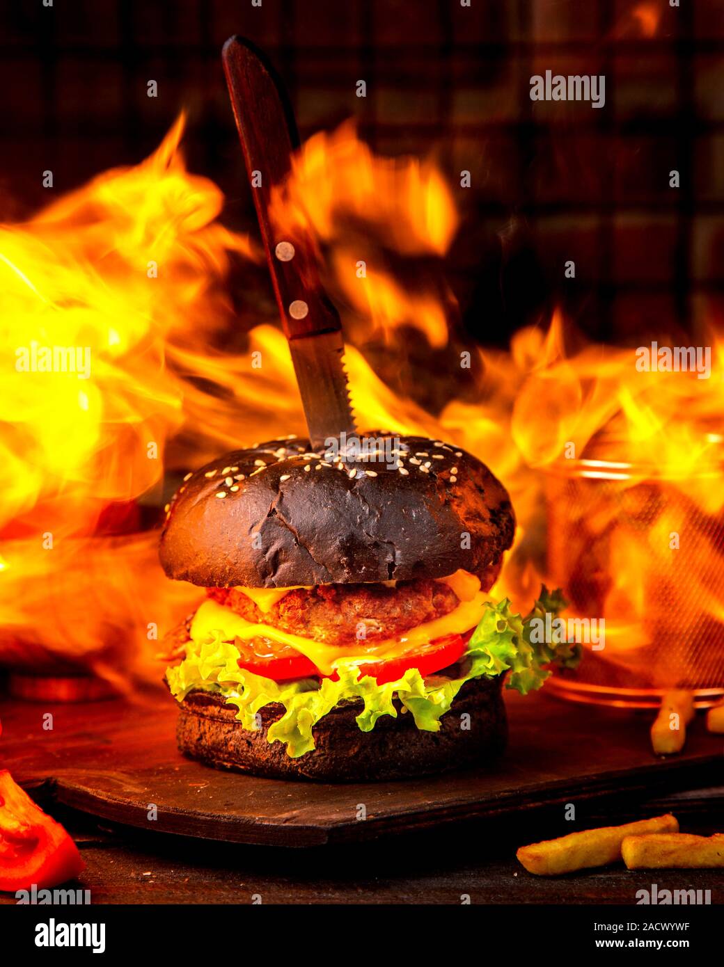 meat double cheeseburger in brown bread on a background of fire Stock ...