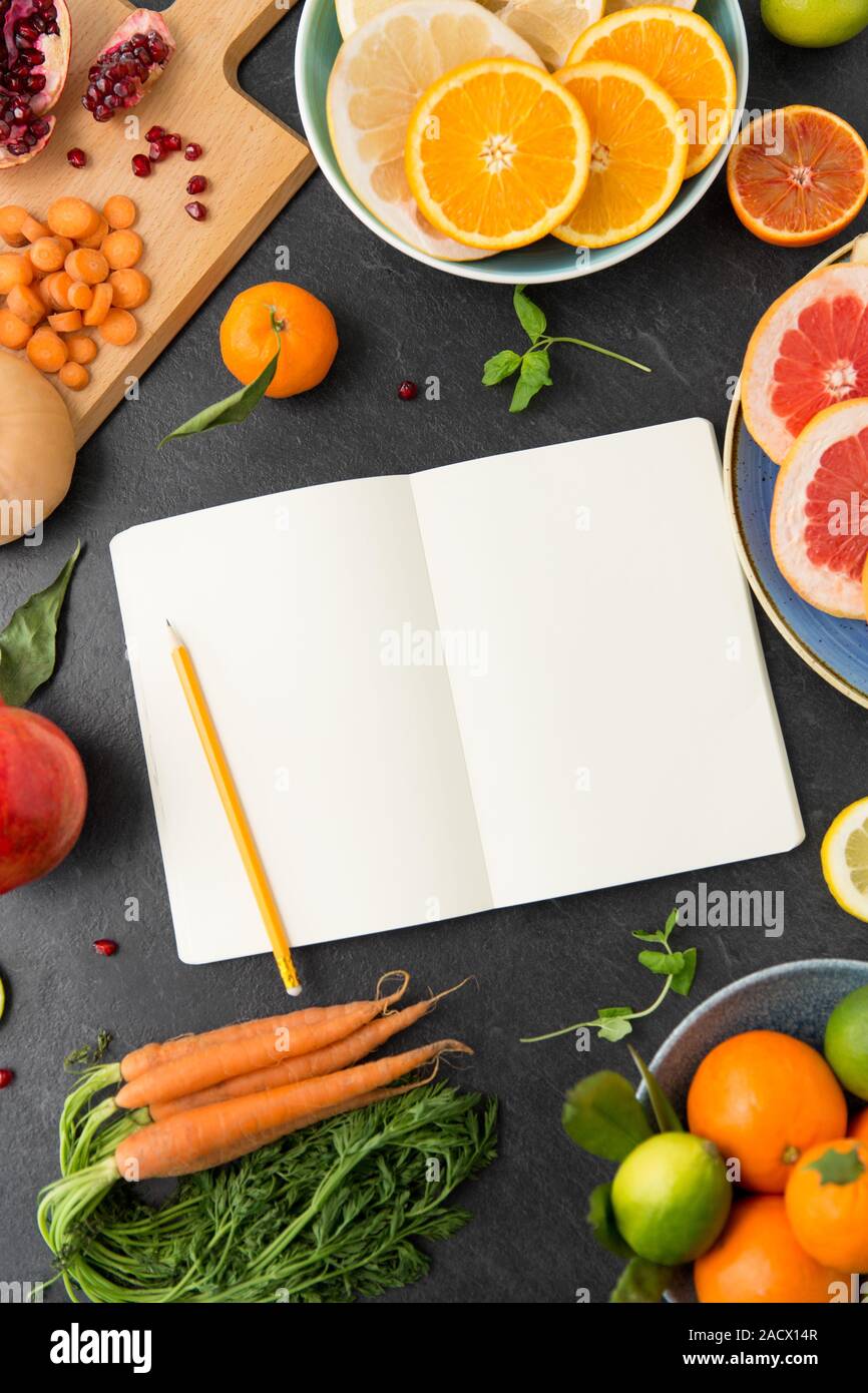 food, healthy eating and diet concept - close up of notebook, fruits ...