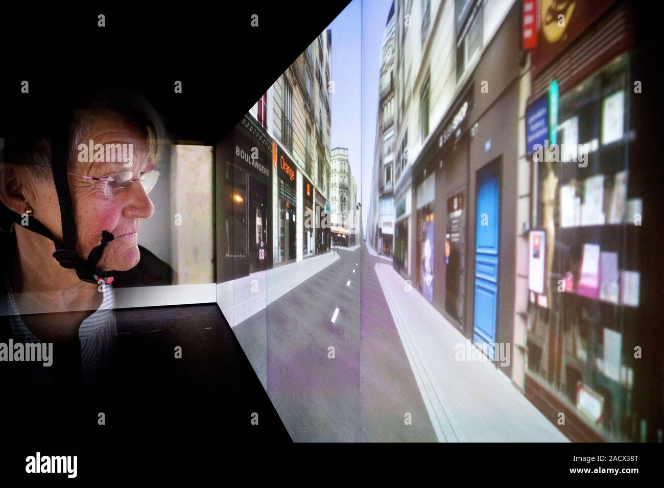 Road safety pedestrian simulation. Elderly woman preparing to cross a road as part of a ...