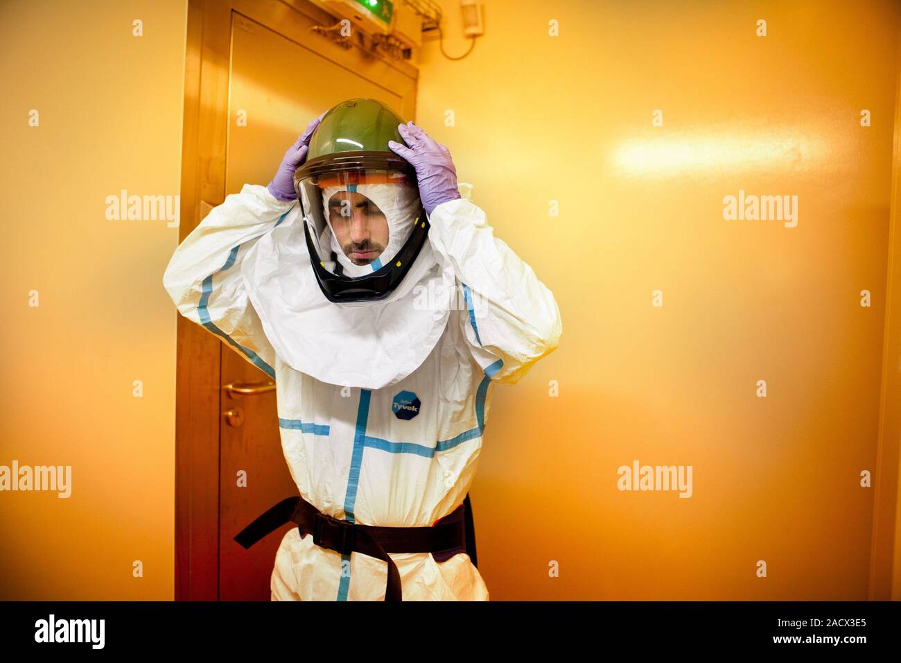 Scientist putting on protective clothing before entering a high-risk ...