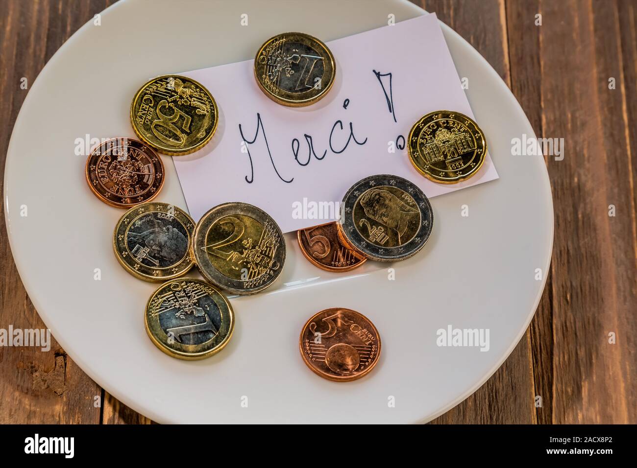 Plate with coins Stock Photo - Alamy
