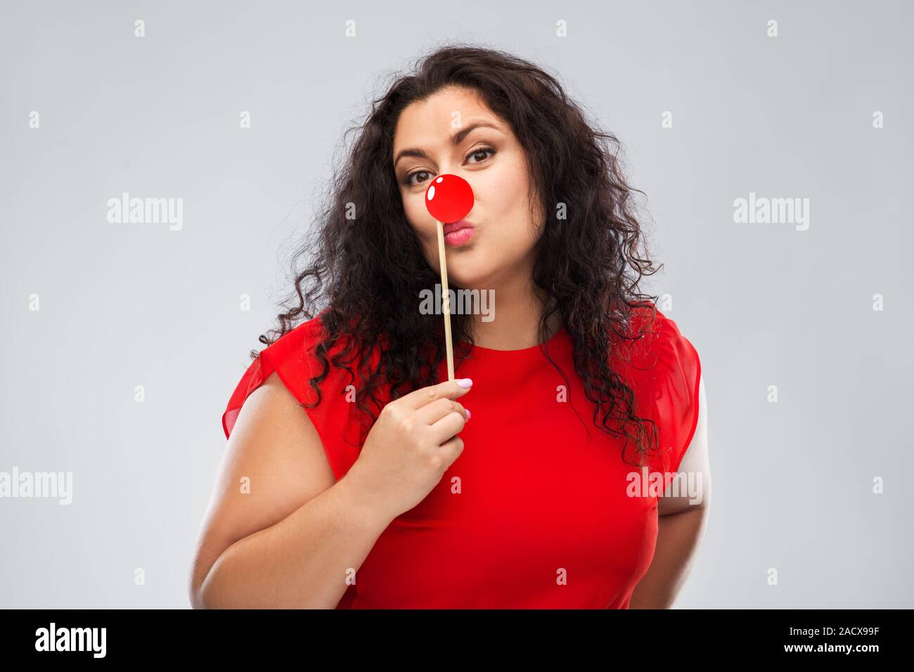 red nose day, party props and photo booth concept - happy woman with ...