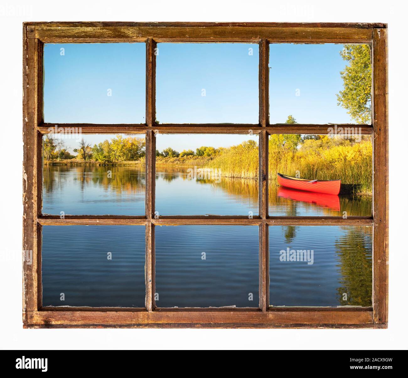 red tandem canoe on a calm lake shore as seen from a vintage cabin ...