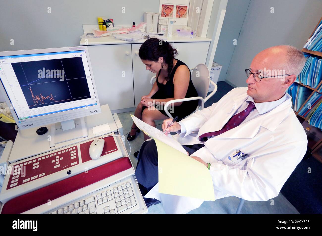 Urodynamic tests. A doctor testing a patient's urinary flow. Urodynamic ...