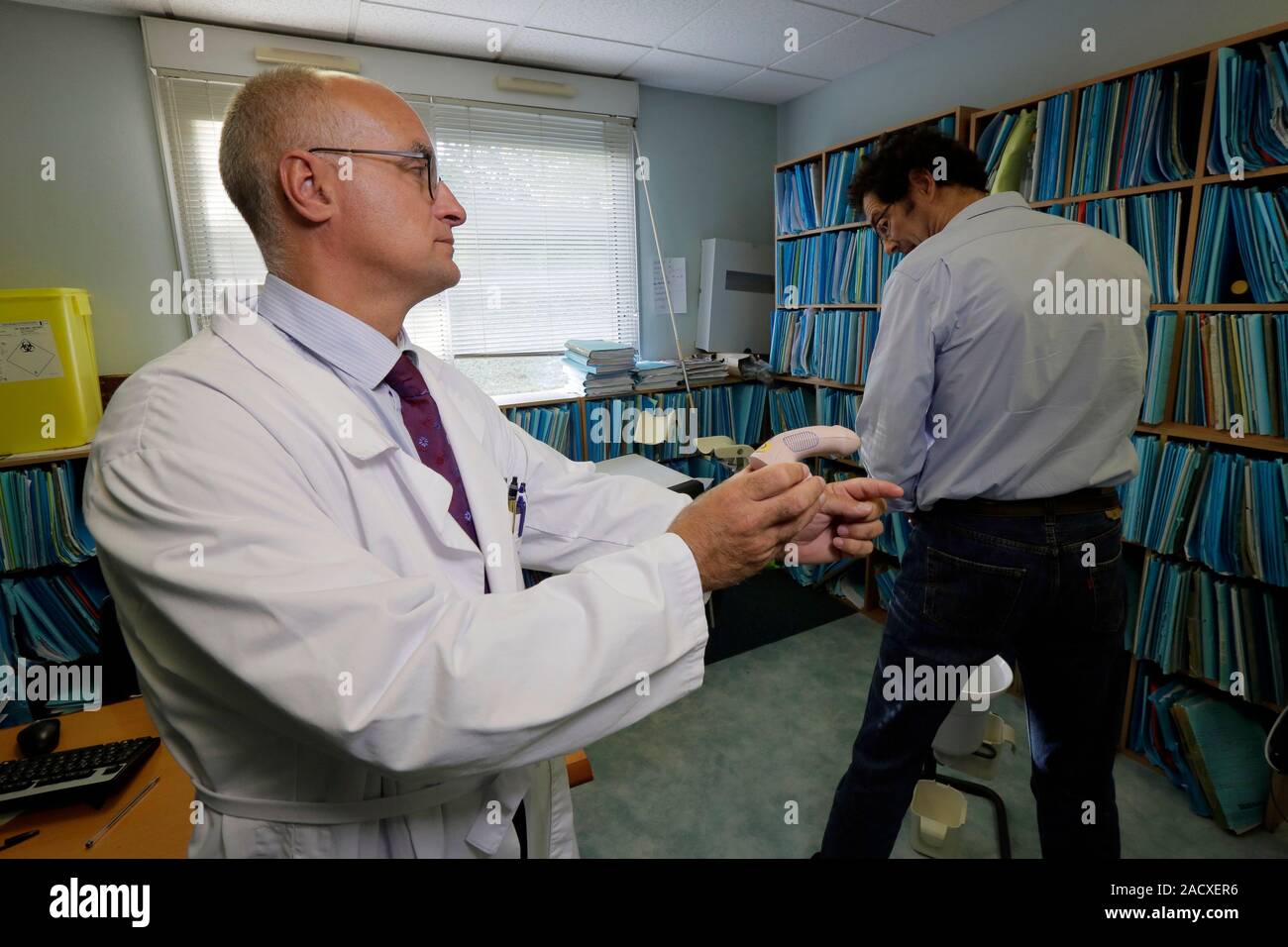 Urodynamic tests. A doctor testing a patient's urinary flow. Urodynamic ...