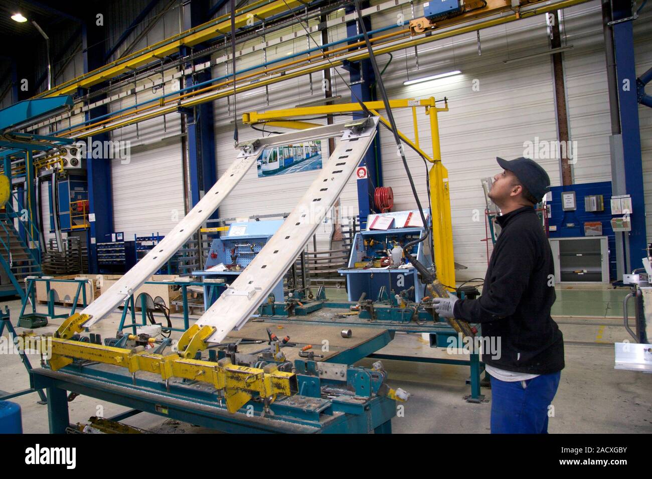 Installing sliding door for a tram. Skilled worker operating machinery ...