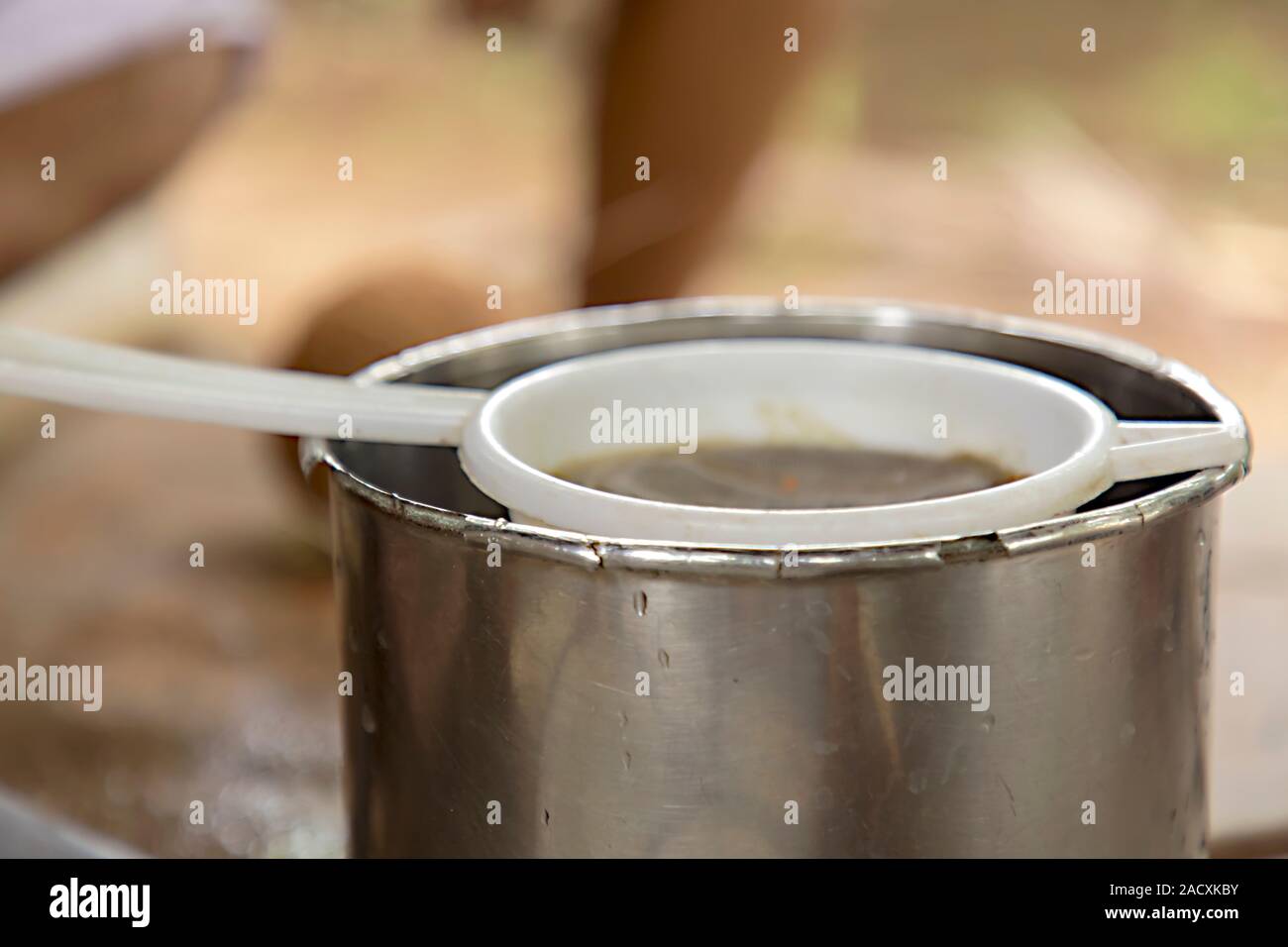 Closeup strainer with container background Stock Photo - Alamy