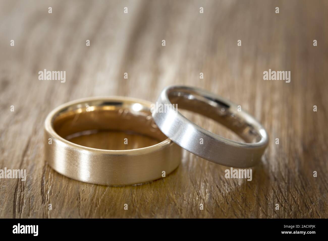 Two wedding rings on oak board Stock Photo - Alamy