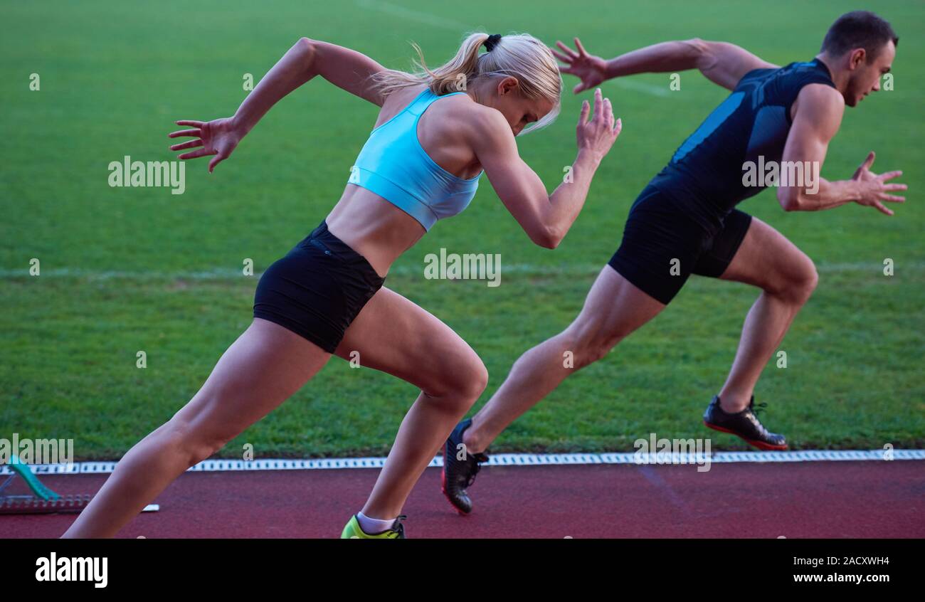 woman group running on athletics race track from start Stock Photo - Alamy