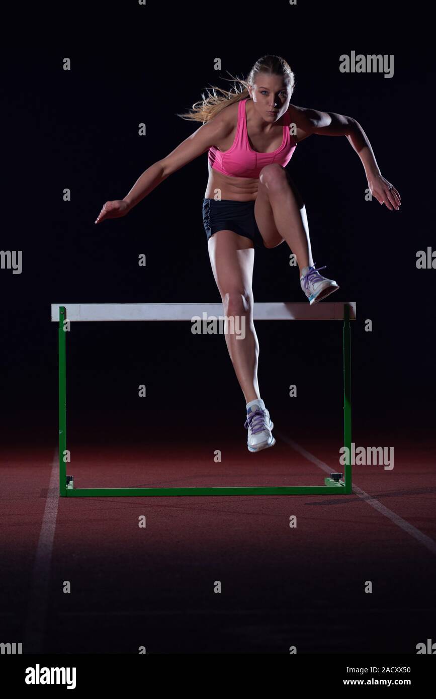 woman athlete jumping over a hurdles Stock Photo - Alamy