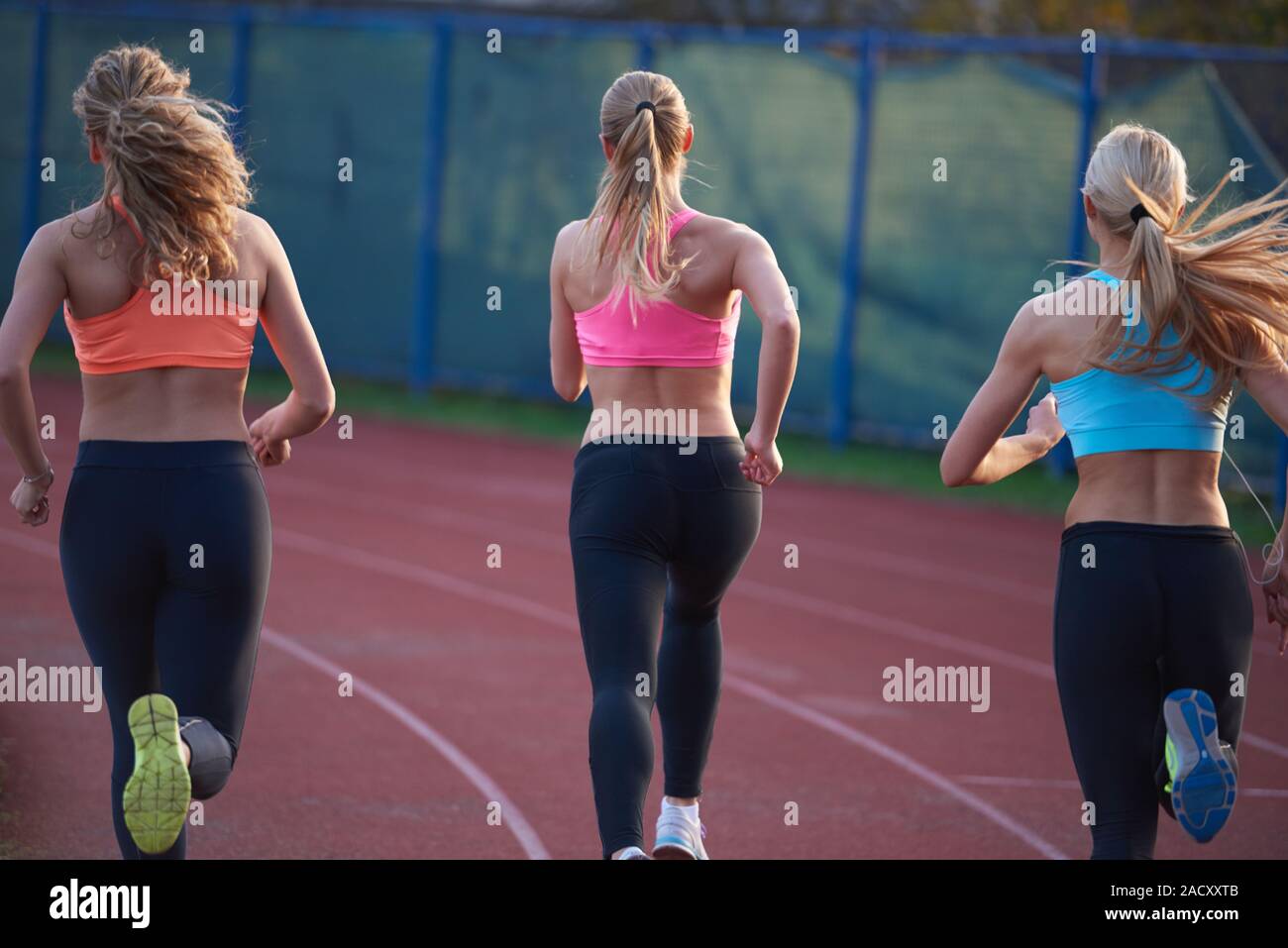 athlete woman group running on athletics race track Stock Photo - Alamy