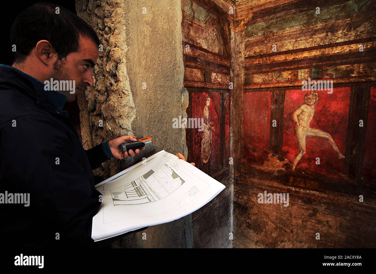 Restoration of Roman frescoes. Archaeologist inspecting a fresco in the ...