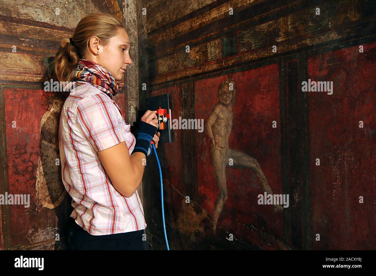 Restoration of Roman frescoes. Archaeologist using a laser to restore a ...