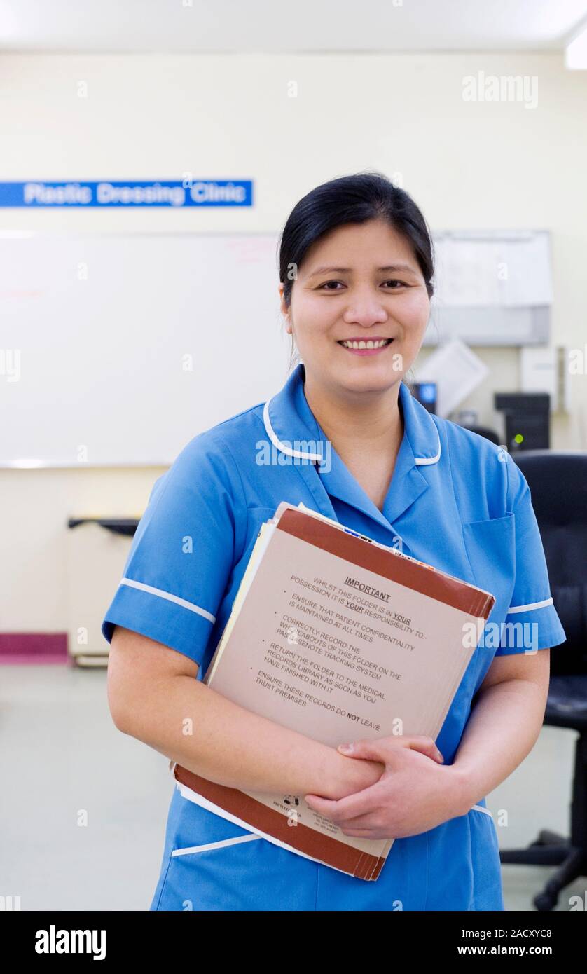 Hospital nurse carrying patient notes Stock Photo - Alamy