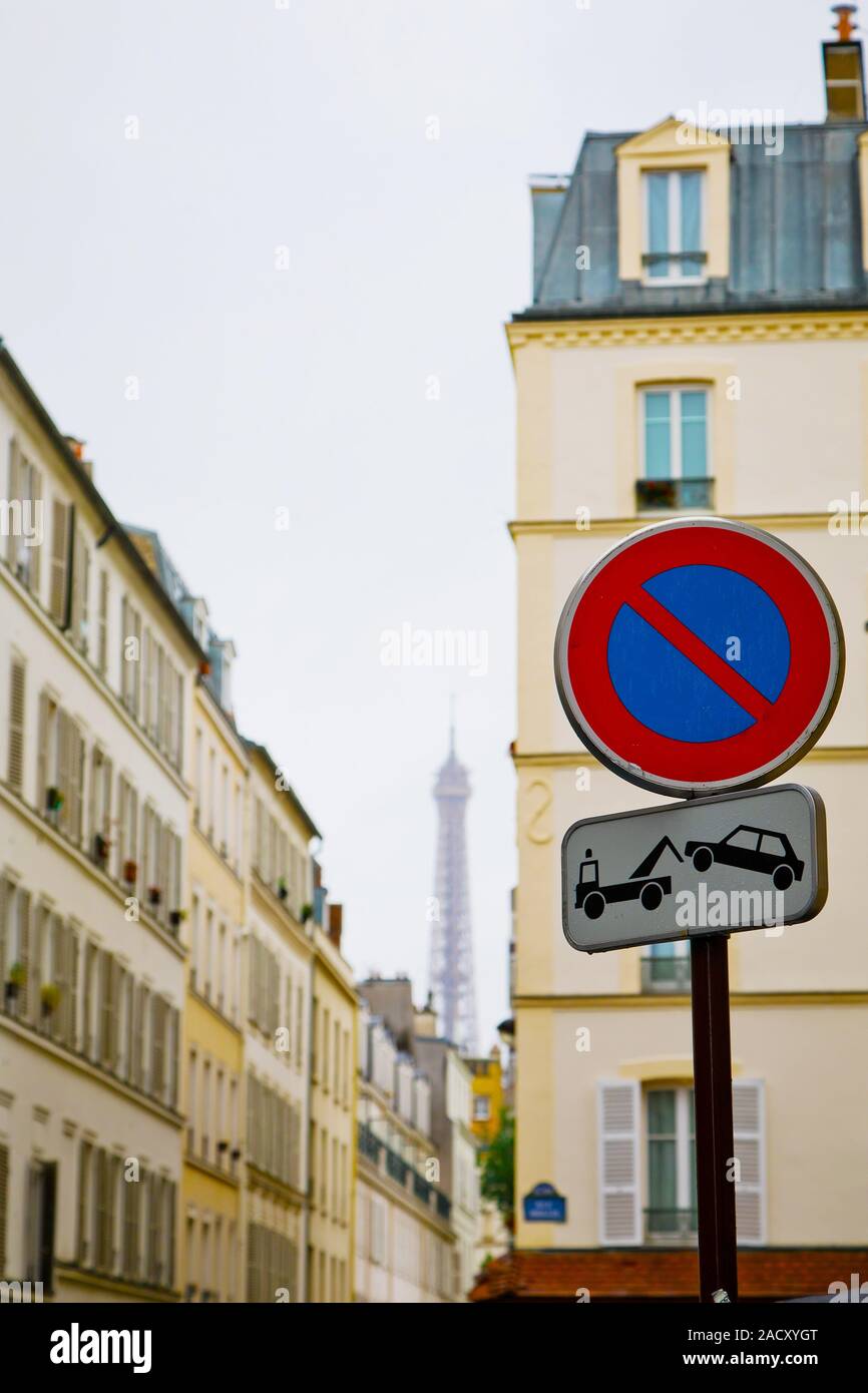 No parking sign in Paris street, top of Eiffel tower in background ...