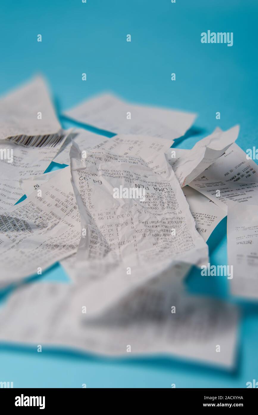 Pile of shopping receipts on a blue background Stock Photo - Alamy