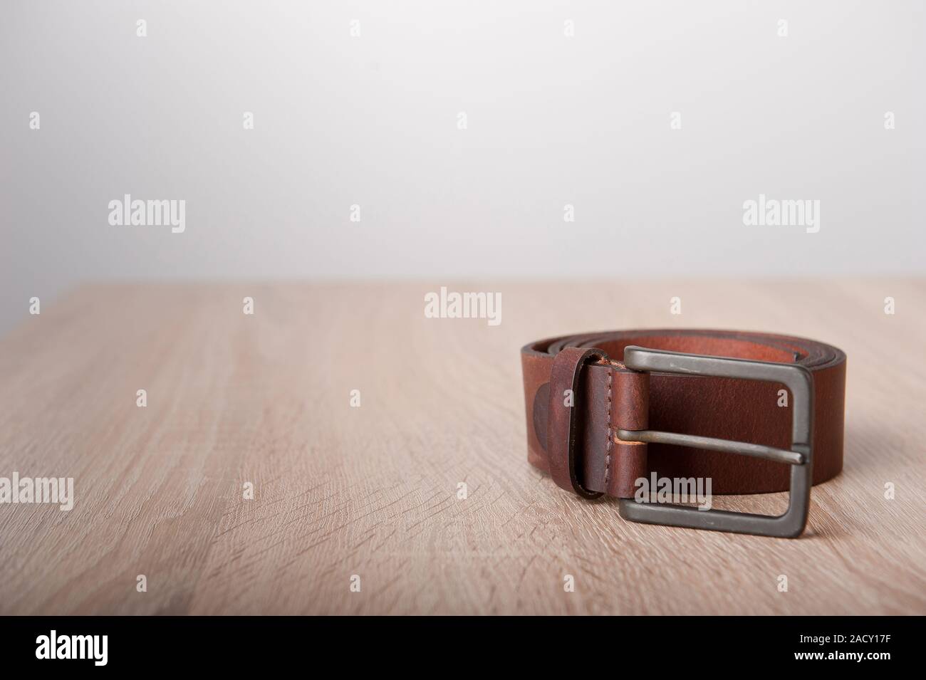 Leather belt on the wooden desk table Stock Photo - Alamy