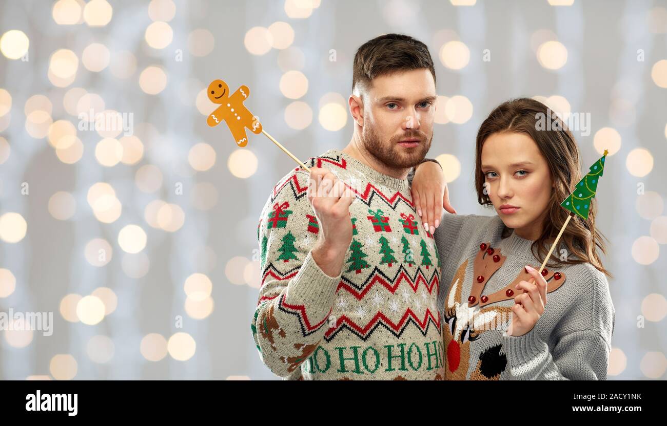 christmas, photo booth and holidays concept - sad couple in ugly ...