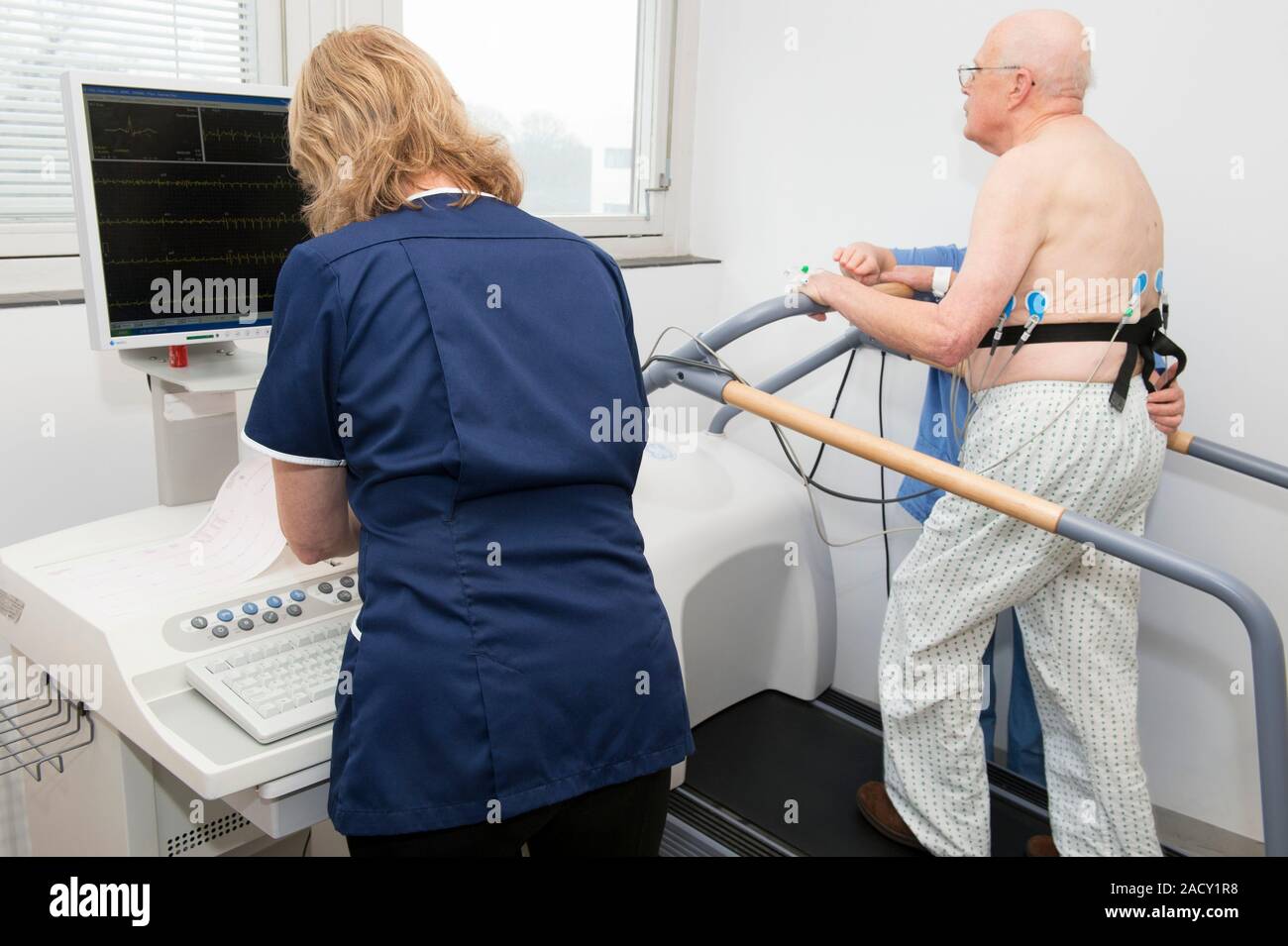 Exercise ECG. An elderly man undergoing exercise testing on a treadmill ...