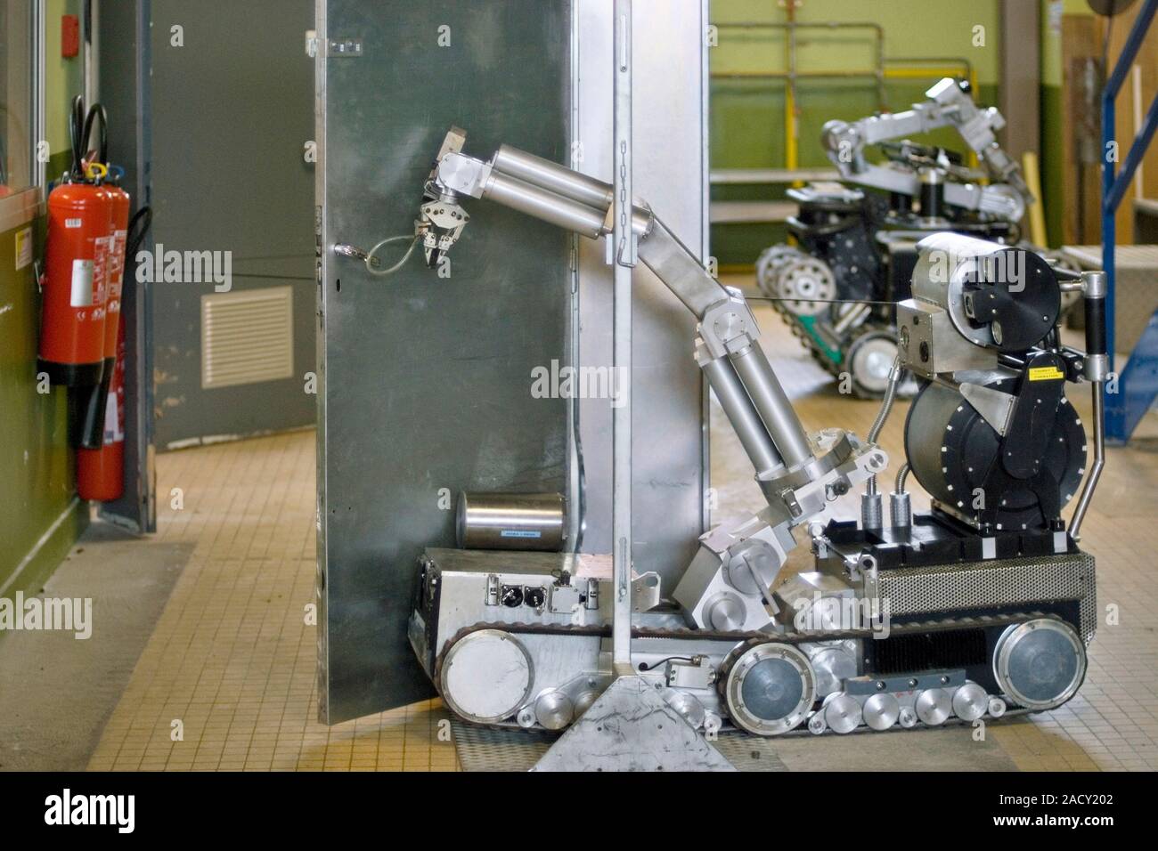 Emergency response robot opening a door. This is the EROS robot used by ...