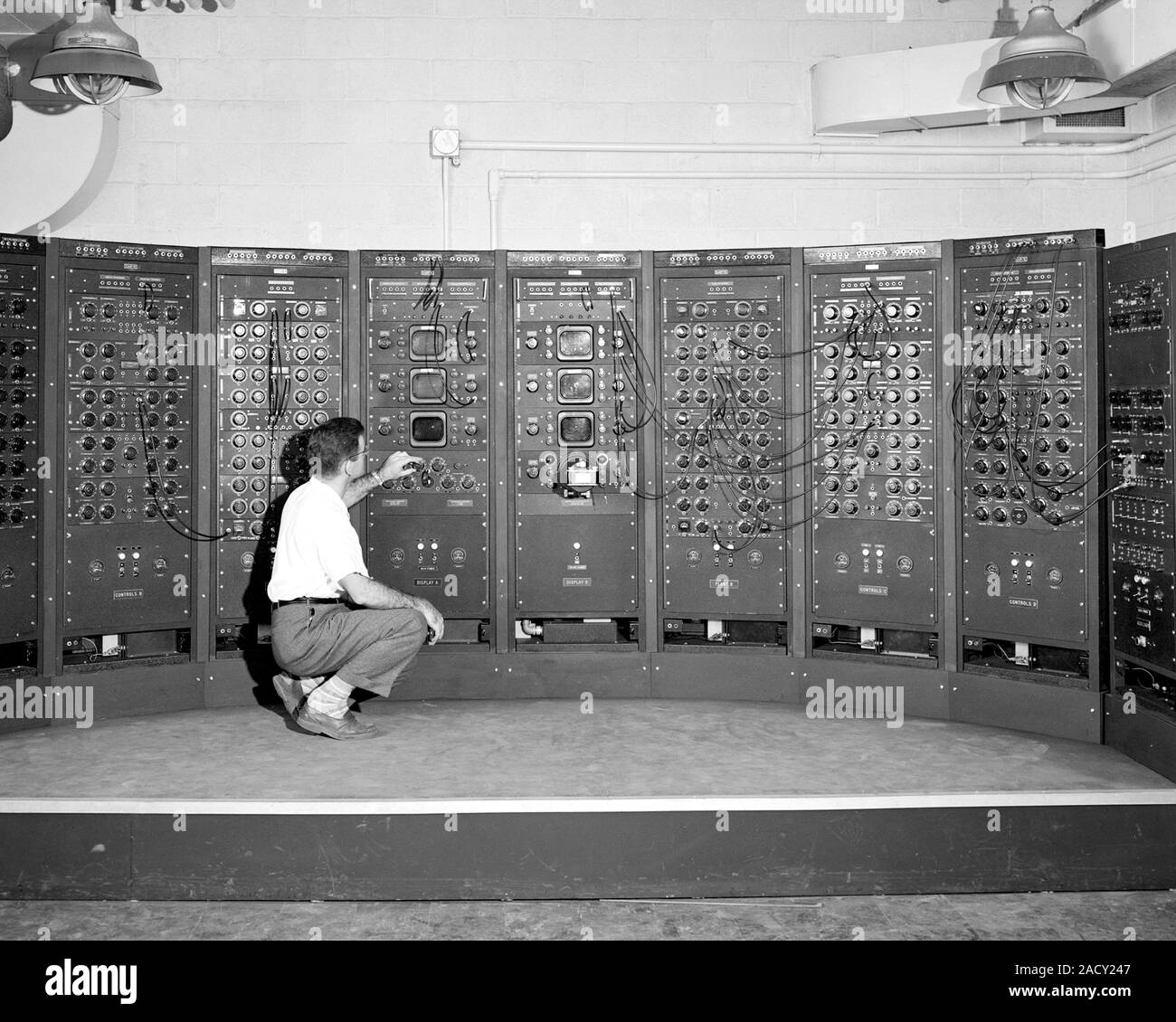 Analogue computer. Technician using an analogue computing machine, an ...