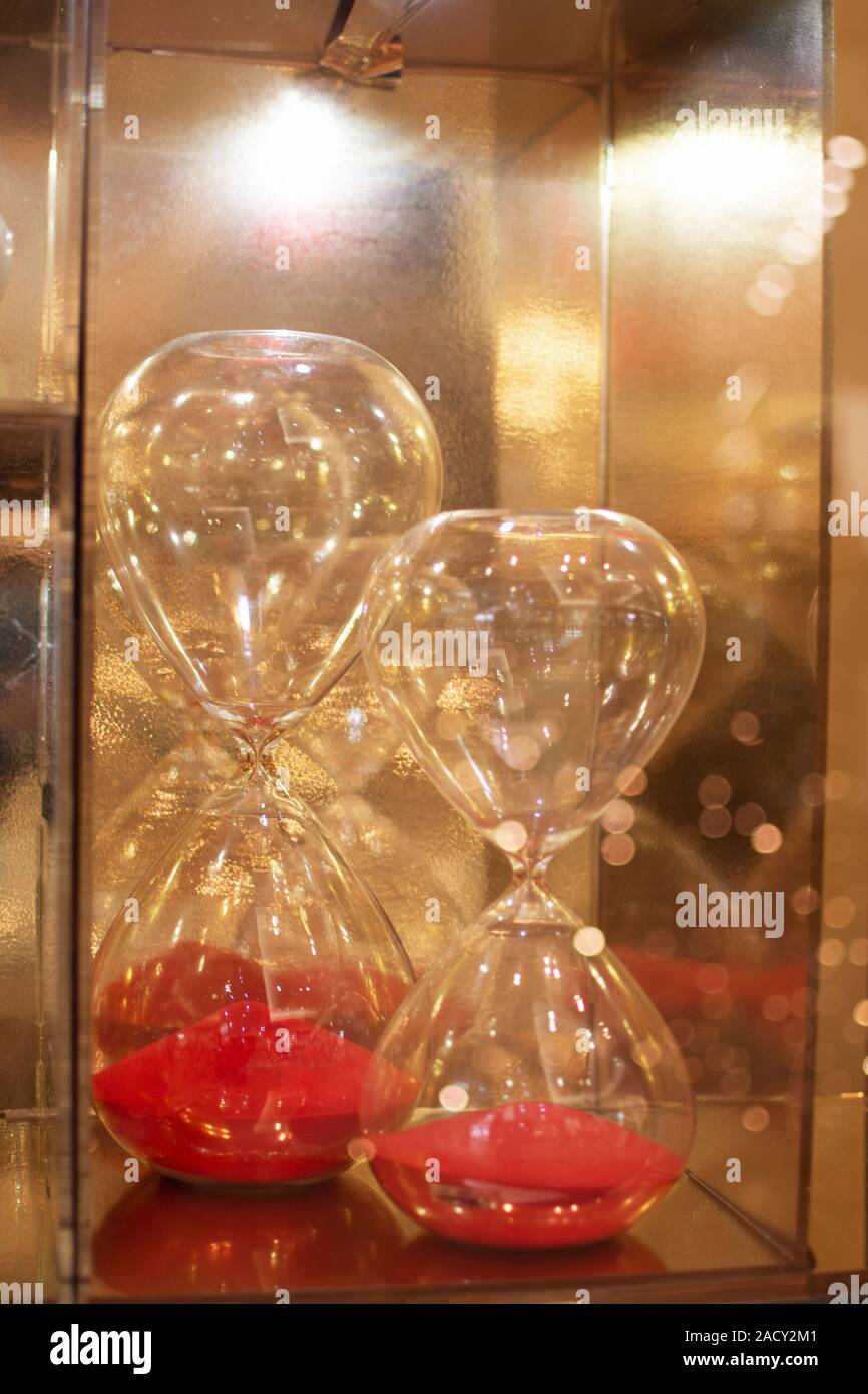 Two hourglass on mirror background in golden lights Stock Photo - Alamy