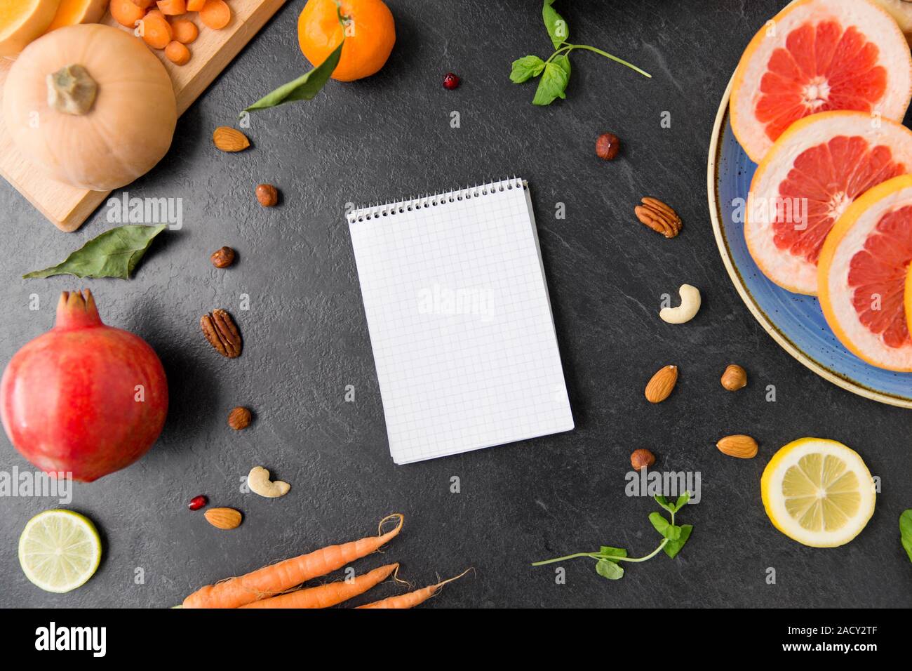 food, healthy eating and diet concept - close up of notebook, fruits ...
