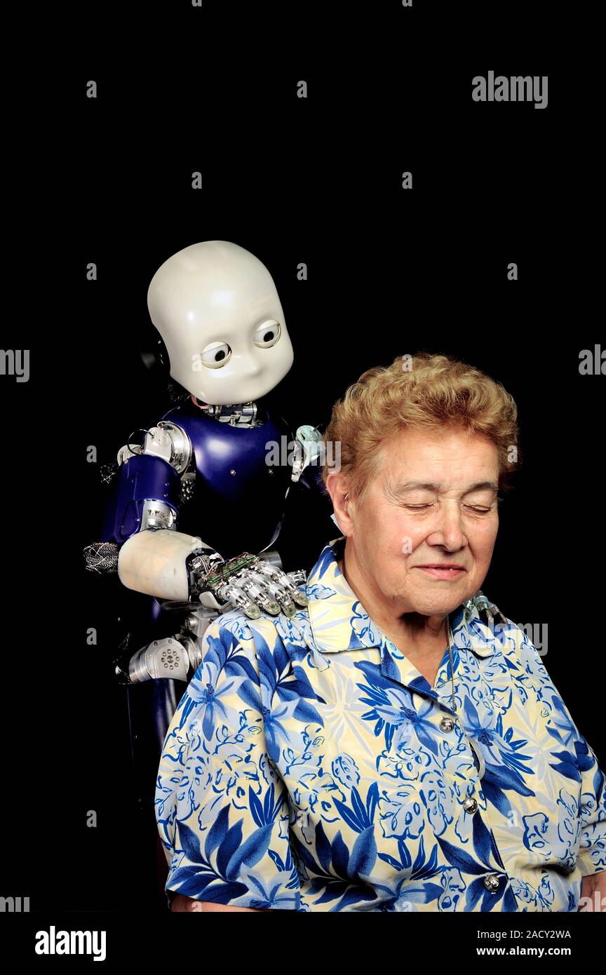 iCub robot interacting with an older woman. The iCub is a small ...