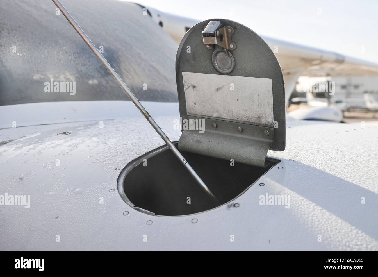 Pilot perform a preflight check on a cessna skyhawk checking the oil ...