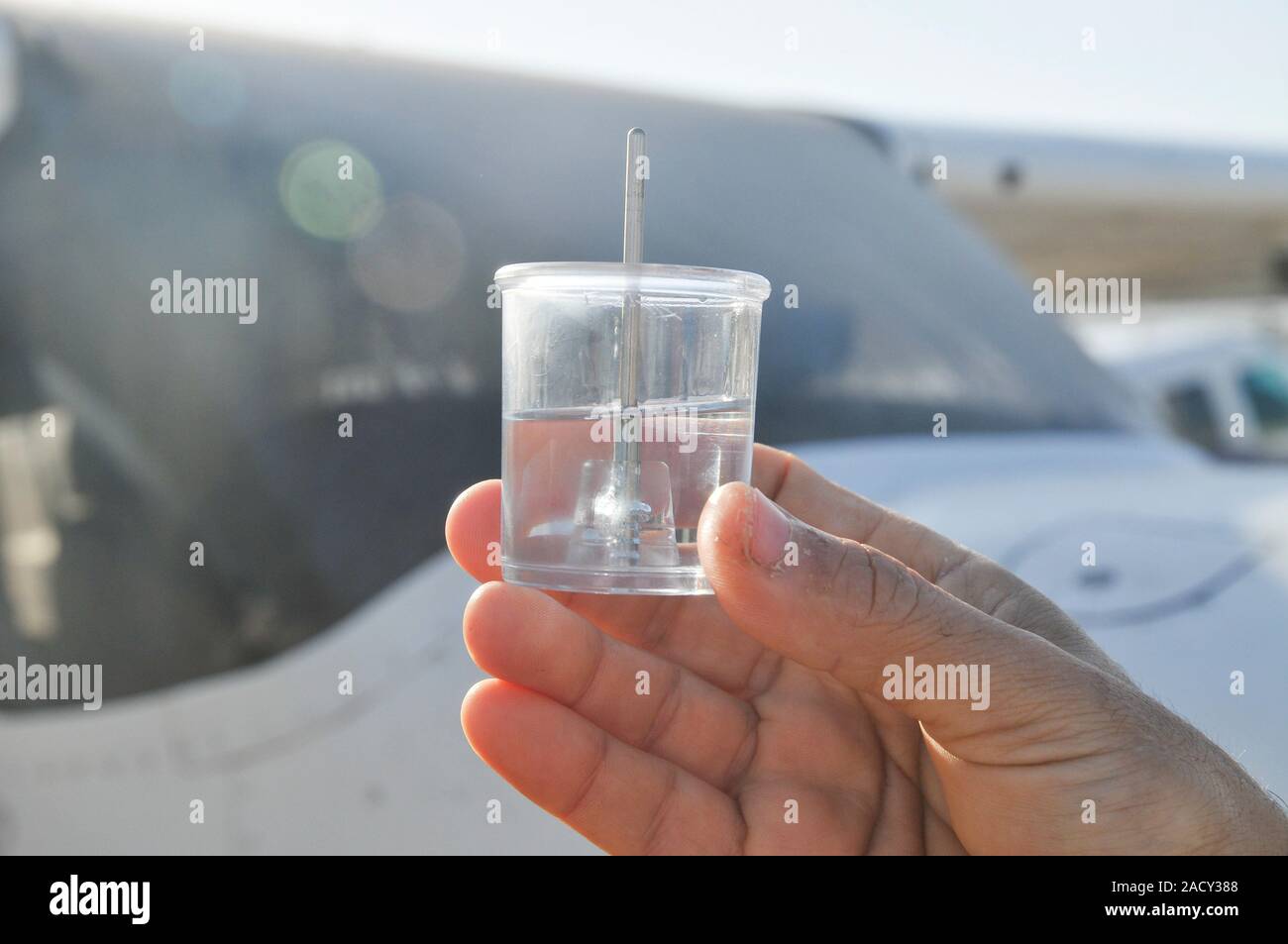 Pilot perform a preflight check and checks the petrol quality on a ...