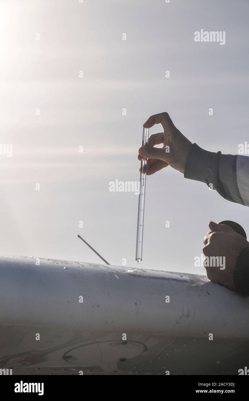 Pilot perform a preflight check and checks the petrol quality on a ...