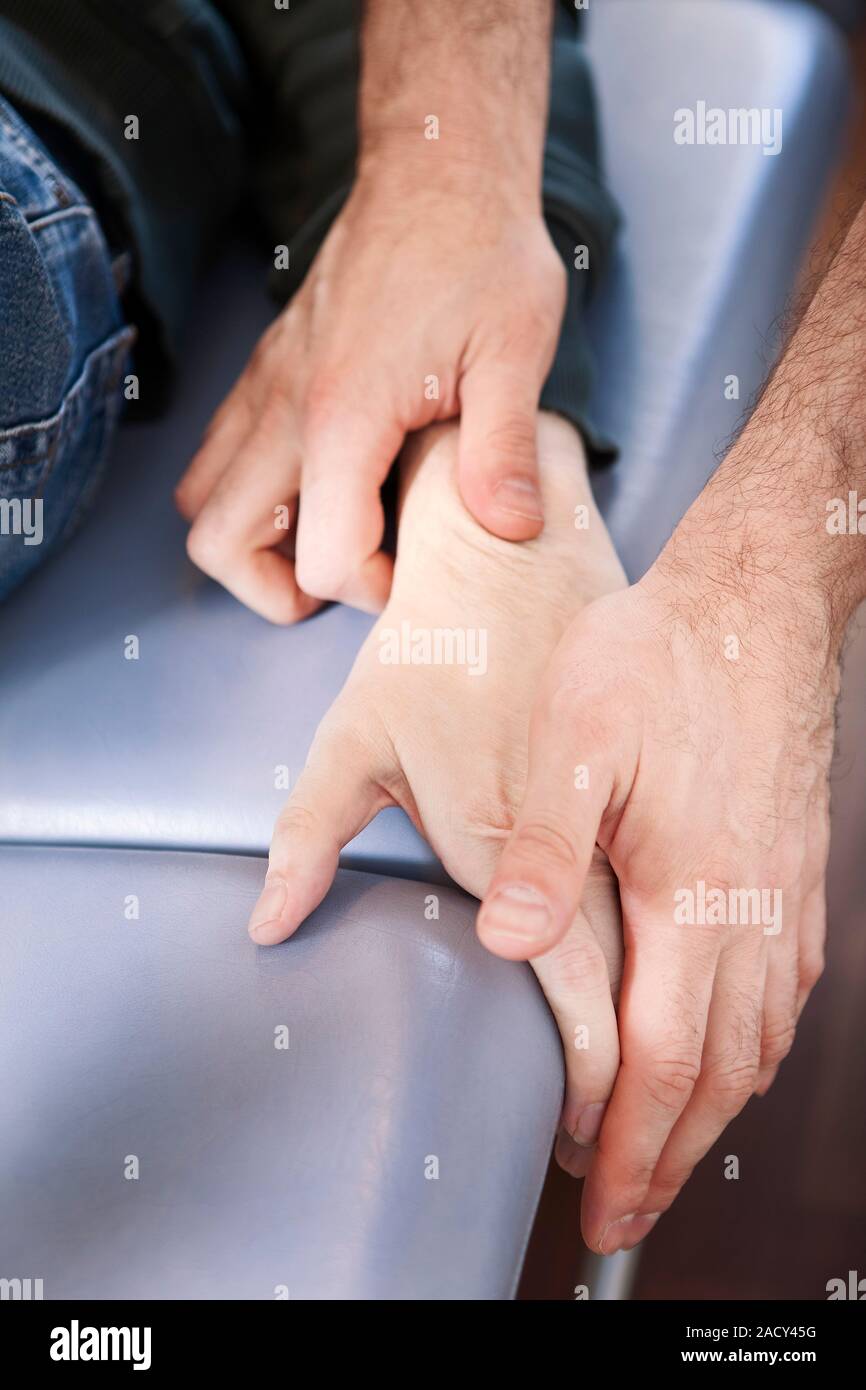 Hemiplegic stroke physiotherapy. Physiotherapist manipulating the left ...