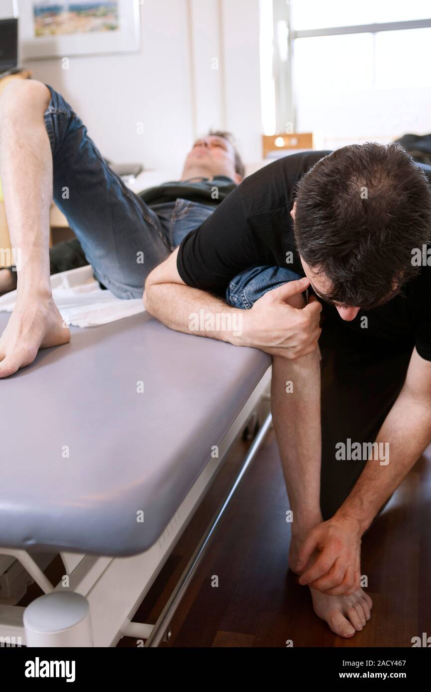 Hemiplegic stroke physiotherapy. Physiotherapist manipulating the left ...