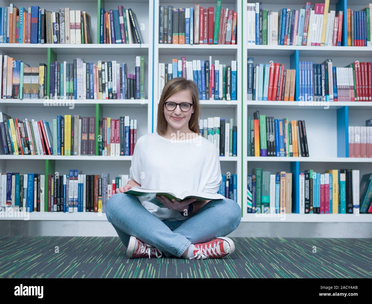 student girl reading book in library Stock Photo - Alamy