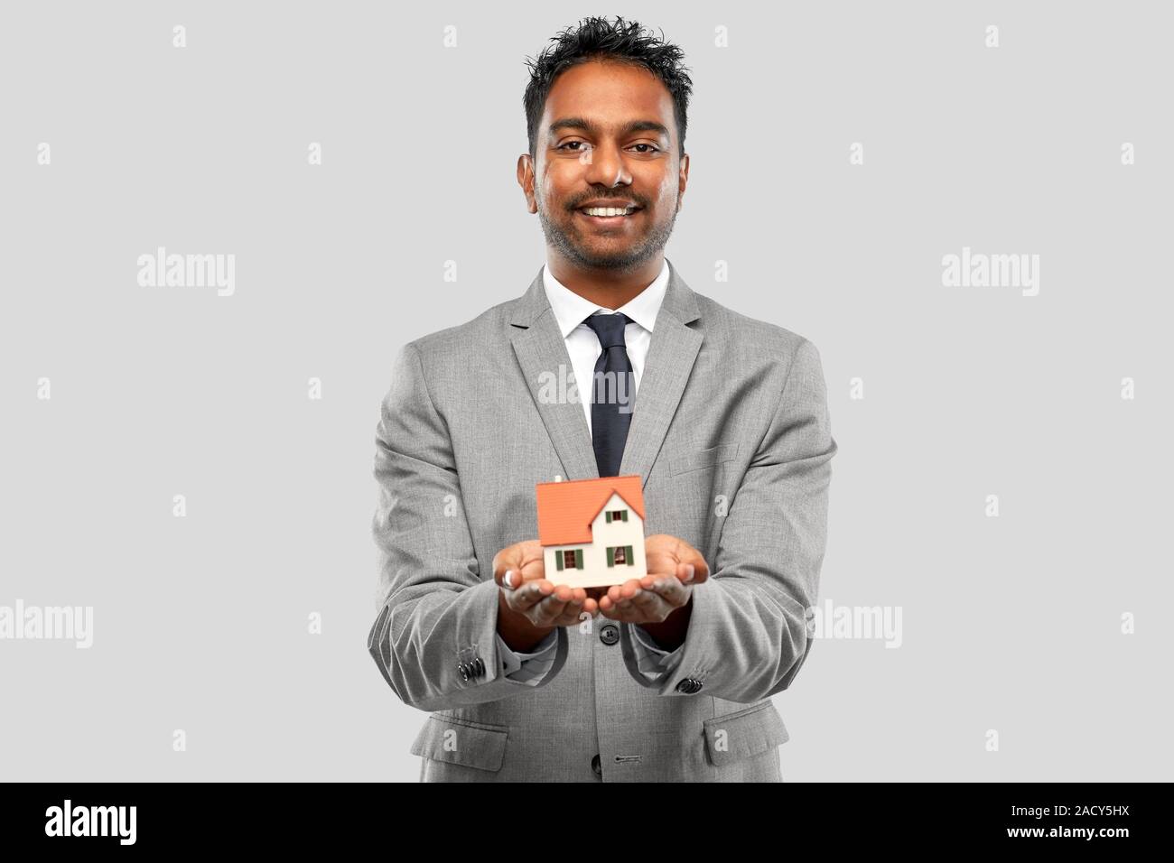 real estate business and people concept - man realtor with house model ...