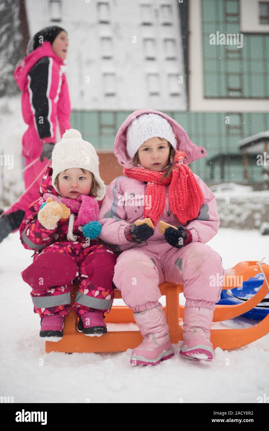 portrait of two little girls sitting together on sledges Stock Photo ...