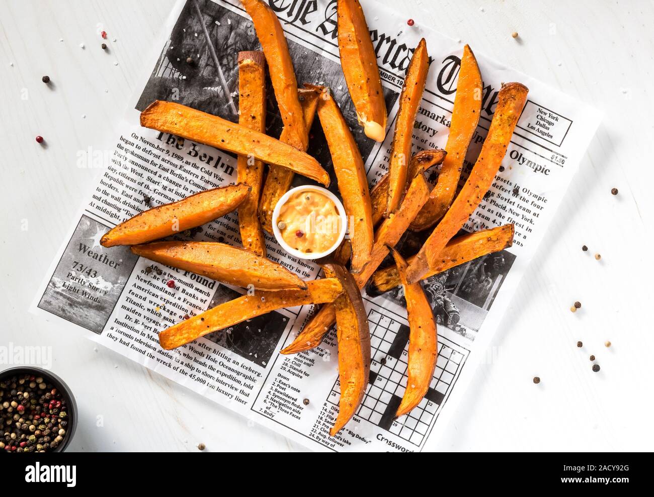 Top down view of steak cut sweet potato fries on newspaper parchment ...