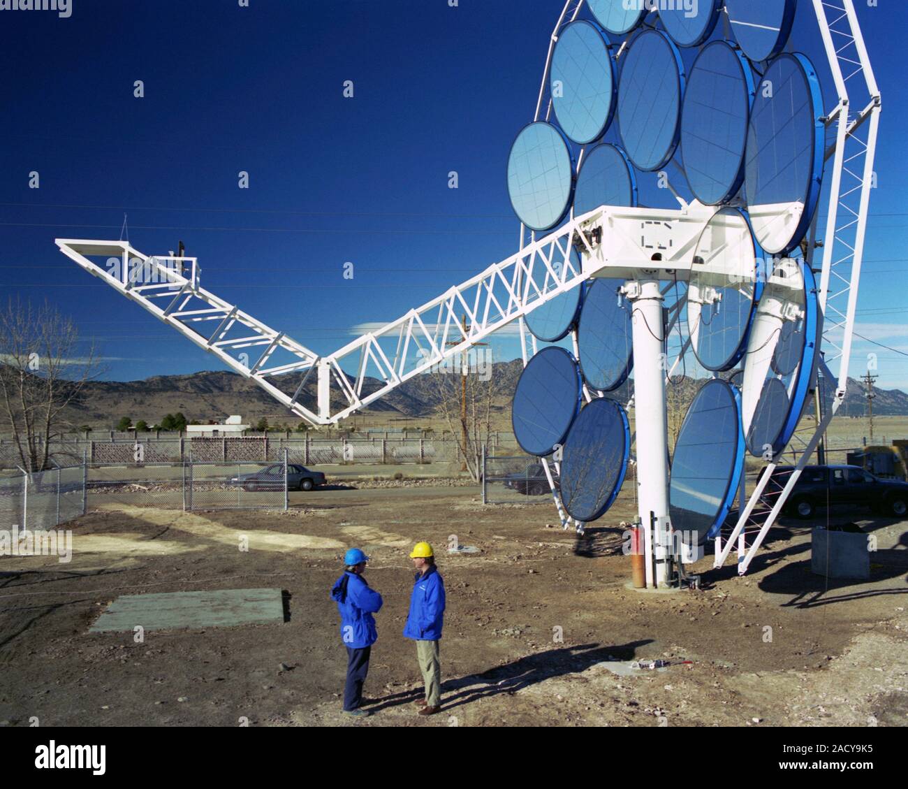 SAIC solar thermal dish. People standing by the solar collector dish ...