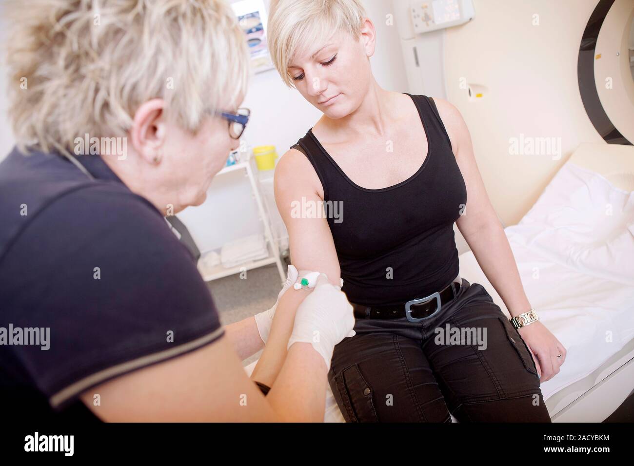 Removal of intravenous drip from a patient's arm after a CT scan. Also ...