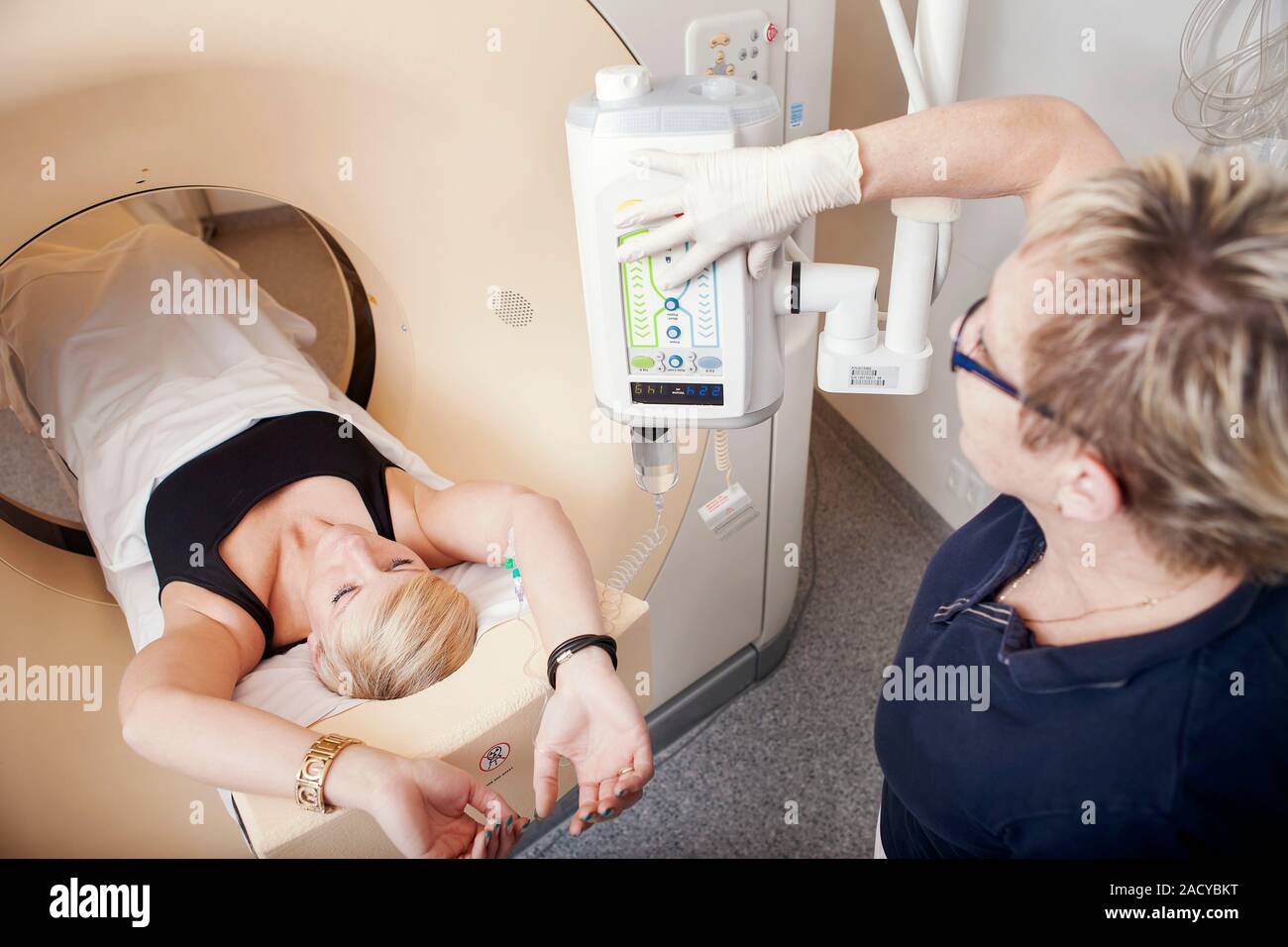 A radiologist operates the controls of a contrast medium injector prior ...